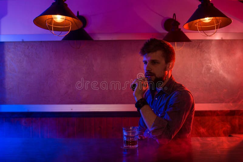 The Man Smoke an Electronic Cigarette at the Vape Shop. Stock Image ...
