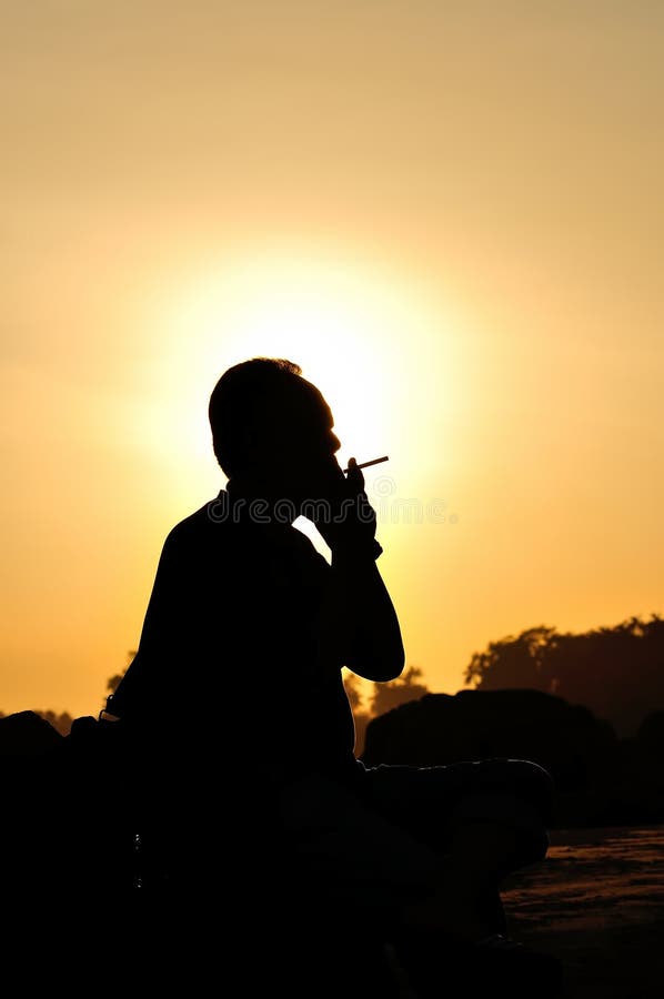 A Man Smoking Cigarette Over Golden Sunset Stock Photo - Image of ...