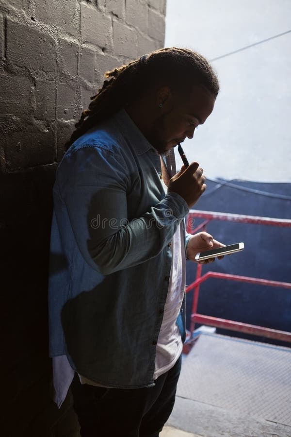 Man Smoking while Using Mobile Phone Stock Photo - Image of male, adult ...