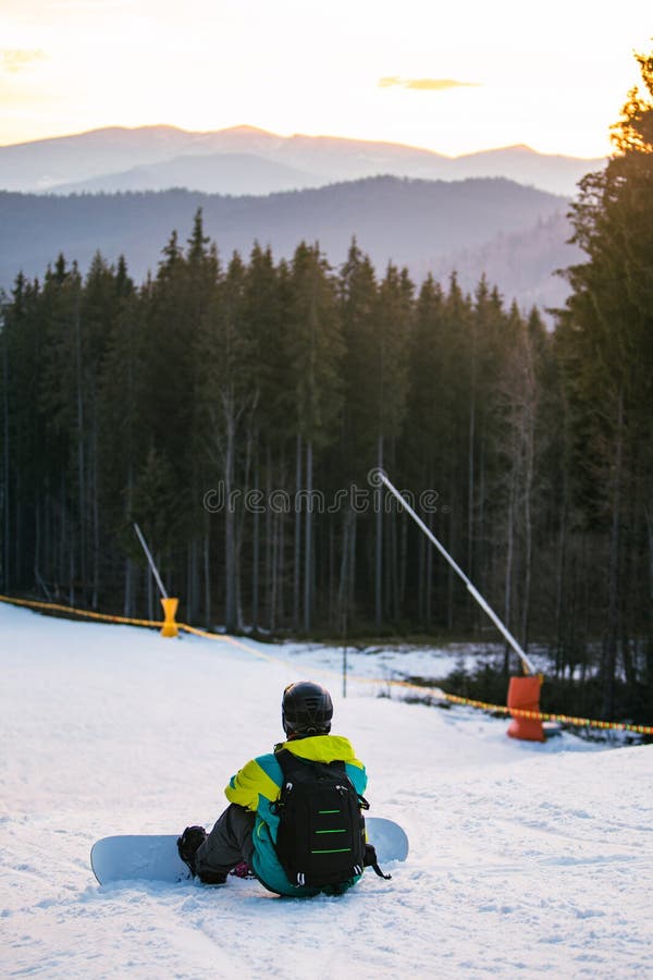 Man with Snowboard Sitting at Slope Enjoying the View Stock Photo ...