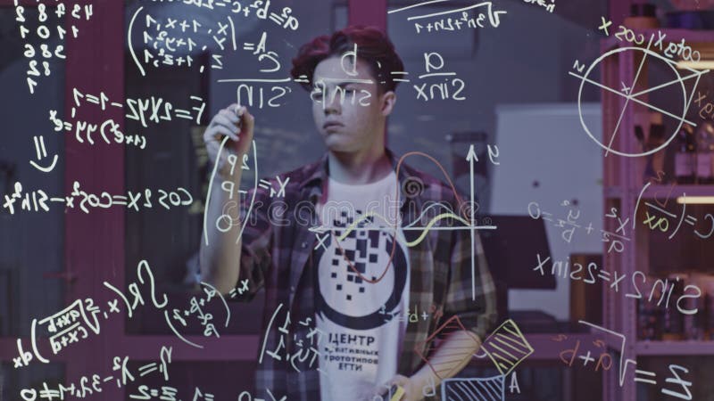 Man Solves Equations on Transparent Board. Media. Young Man Solves ...