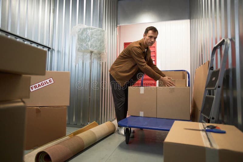 Man Sorting Boxes in Storage Unit Stock Image - Image of rent, male ...