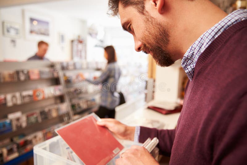 Man and Woman Working Behind the Counter at a Record Shop Stock Image ...