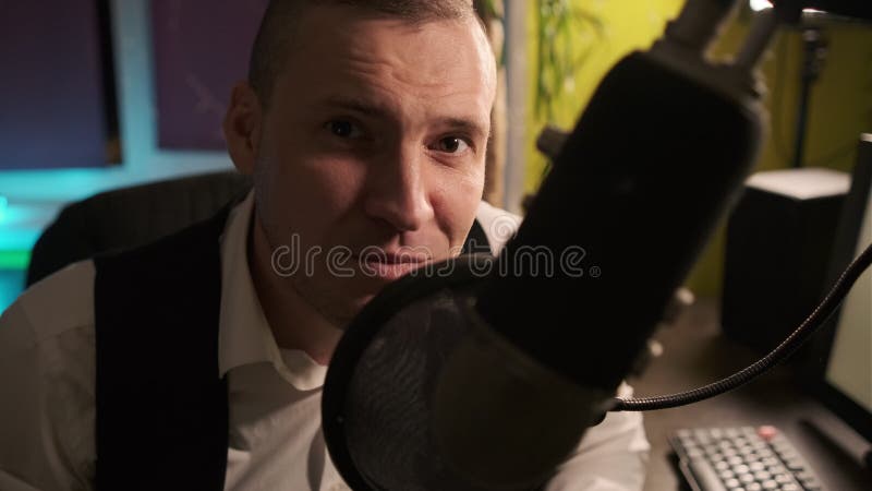 Man Speaking into Professional Microphone in Dark Home Studio during ...
