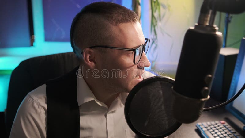 Man Speaking into Professional Microphone in Dark Home Studio during ...