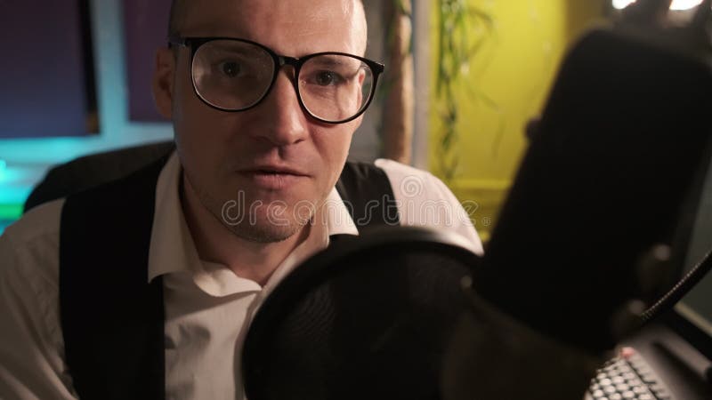 Man Speaking into Professional Microphone in Dark Home Studio during ...