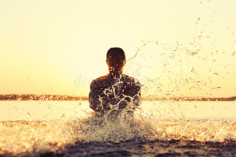 Man Splashing in the Water at Sunset Stock Photo - Image of healthy ...