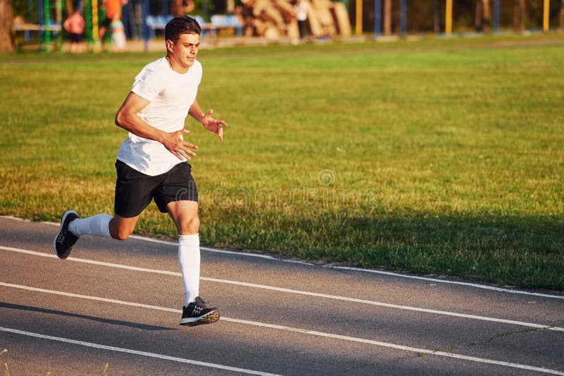 Man in Sportive Unifrom Running on the Track at Daytime Stock Photo ...