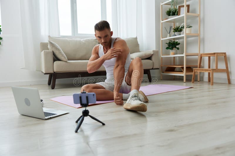Man Sports Watching Tape Of Workout On Phone And Repeating Exercises