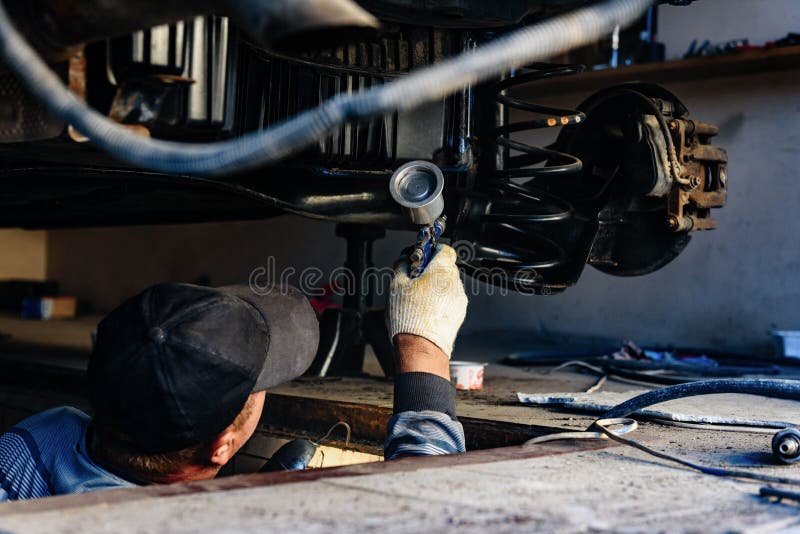 Man Spraying an Anti-corrosion Compound on Bottom of Car. Stock Image ...
