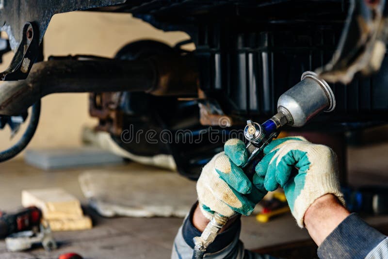 Man Spraying an Anti-corrosion Compound on Bottom of Car. Stock Photo ...