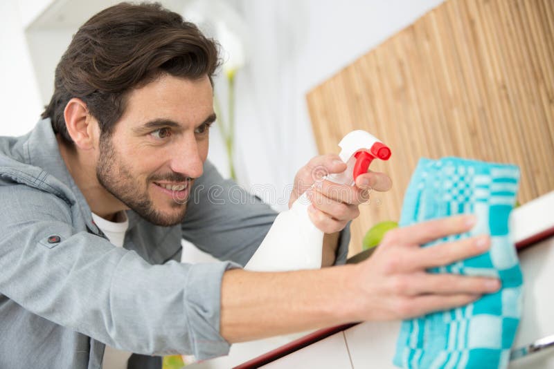 Man Spraying Detergent To Clean Kitchen Worktop Stock Image - Image of ...
