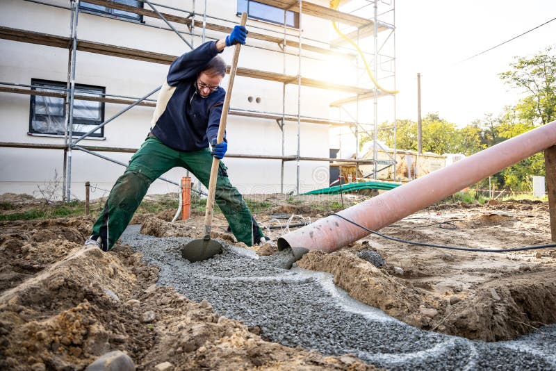 Man Spreading Fresh Concrete for a Building Foundation Stock Image ...