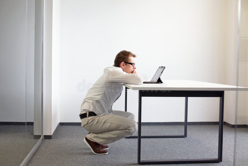 Man Squatting at the Desk, Working with Tablet Stock Image - Image of ...