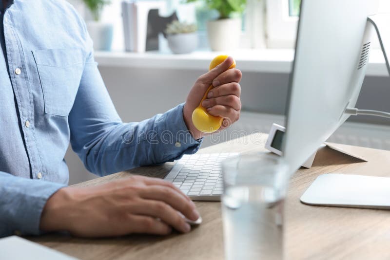 Man Squeezing Antistress Ball while Working with Computer in Office ...