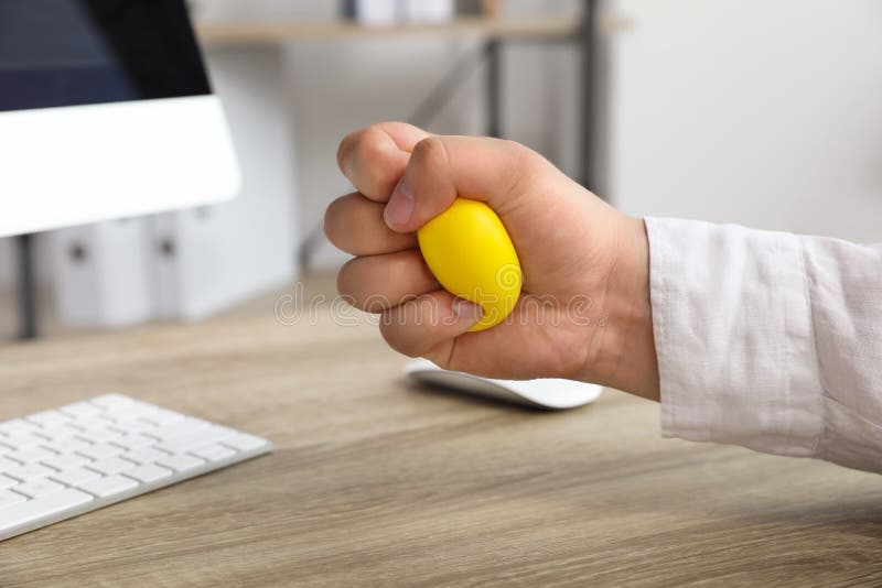 Man Squeezing Yellow Stress Ball in Office, Closeup Stock Image - Image ...