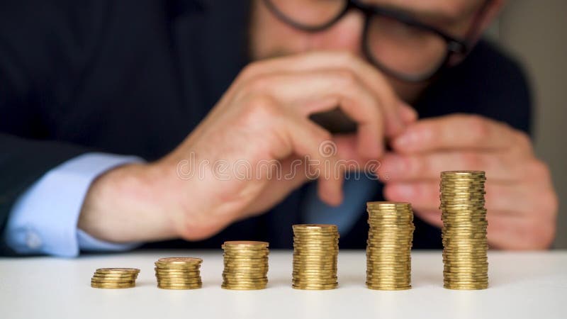 Man Stacking Gold Coins into Increasing Columns Stock Video - Video of ...