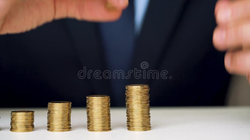 Man Stacking Gold Coins into Increasing Columns Stock Video - Video of ...
