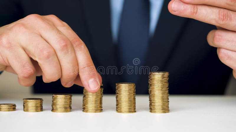 Man Stacking Gold Coins into Increasing Columns Stock Video - Video of ...