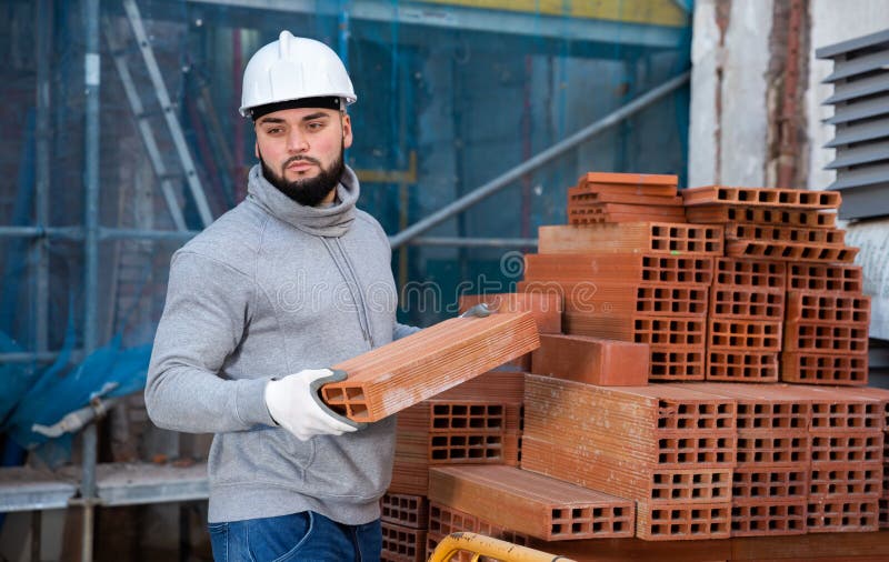 Man stacking red bricks stock photo. Image of stack - 225049076