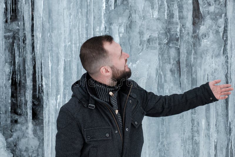 Man Standing Against Cliff Full of Icicles Stock Photo - Image of ...