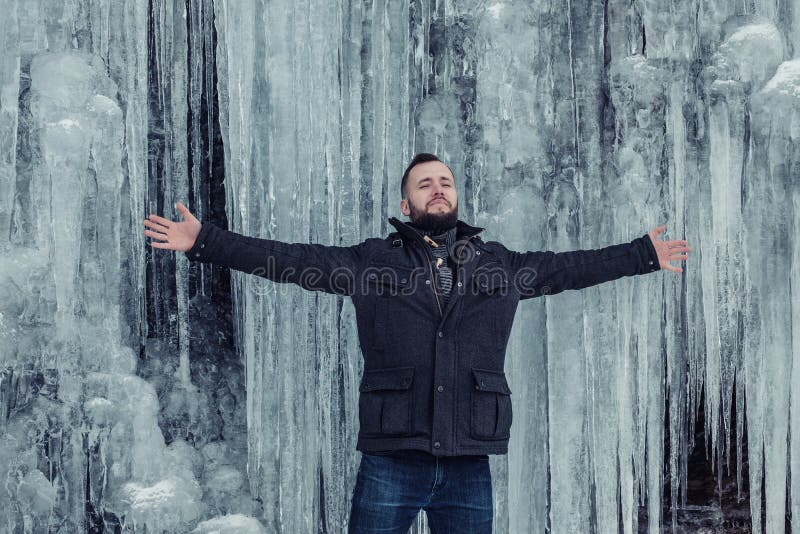 Man Standing Against Cliff Full of Icicles Stock Photo - Image of ...