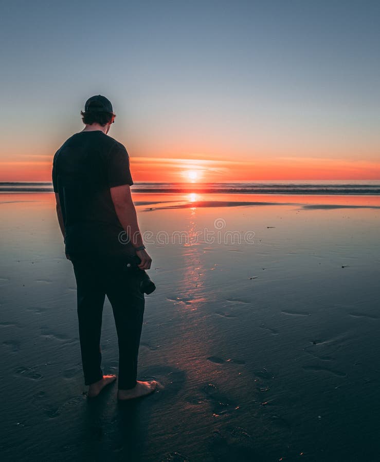 Man Standing On Beach During Sunset Stock Image - Image of shore ...