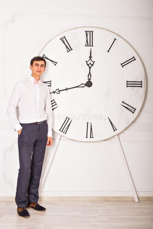 Man Standing beside a Big Clock on White Wall Stock Image - Image of ...