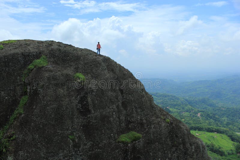 A Man Standing on a Big Rock Stock Photo - Image of rock, standing ...