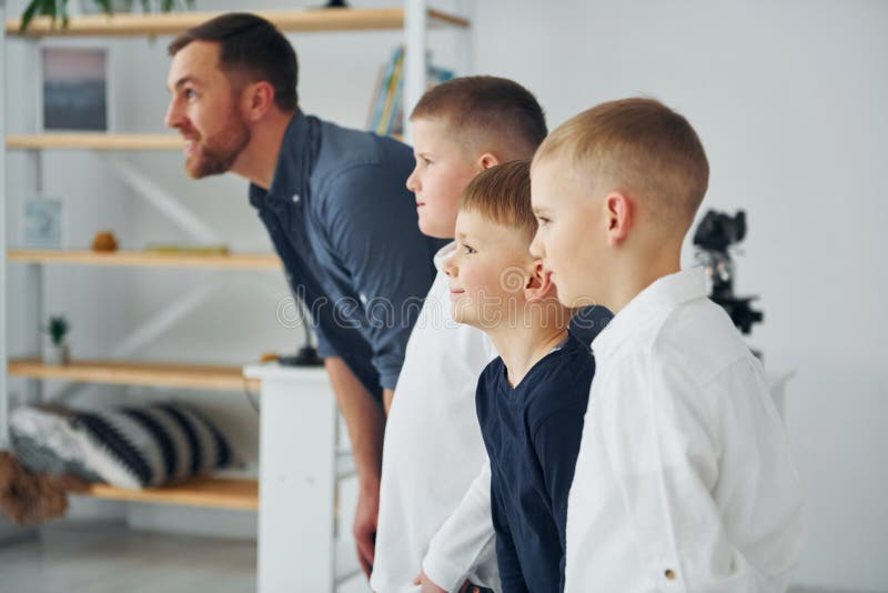 Man Standing with Boys in the Room and Looking To the Side Stock Photo ...