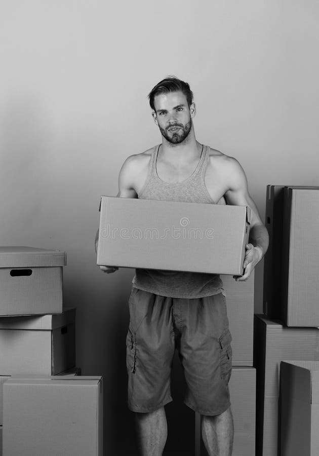 Man Standing Among Cardboard Boxes And Holding One Guy With Beard And