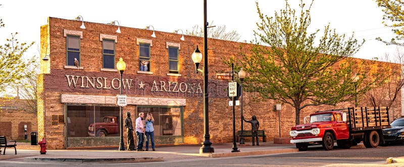 Standing on the Corner Sign with a Statue Covered with Snow in Winslow ...