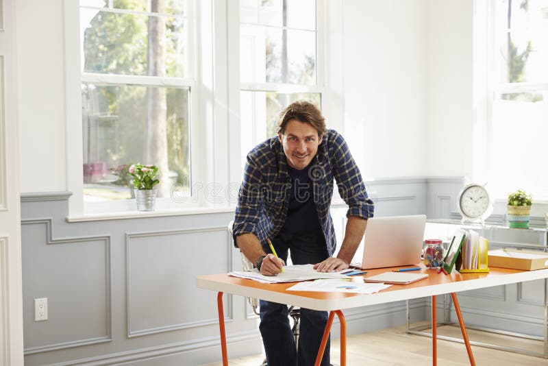Man Standing at Desk Working at Laptop in Home Office Stock Photo ...