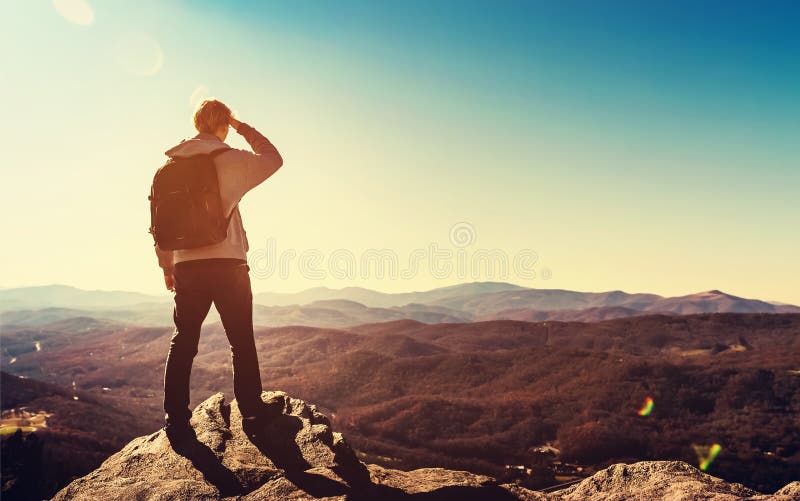 Man Standing at the Edge of a Cliff Overlooking the Mountains Stock ...