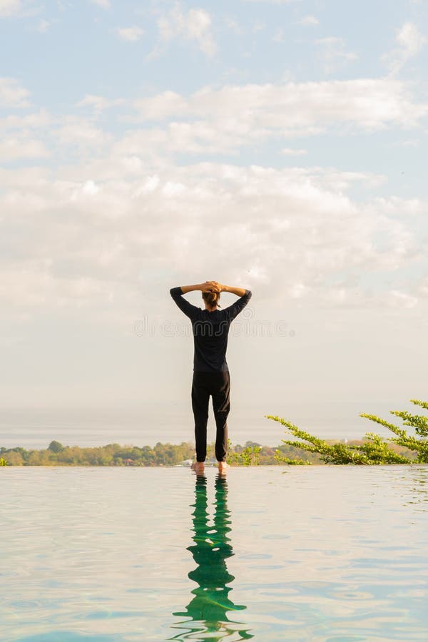 A Man Standing at the Edge of Infinity Pool Stock Photo - Image of ...