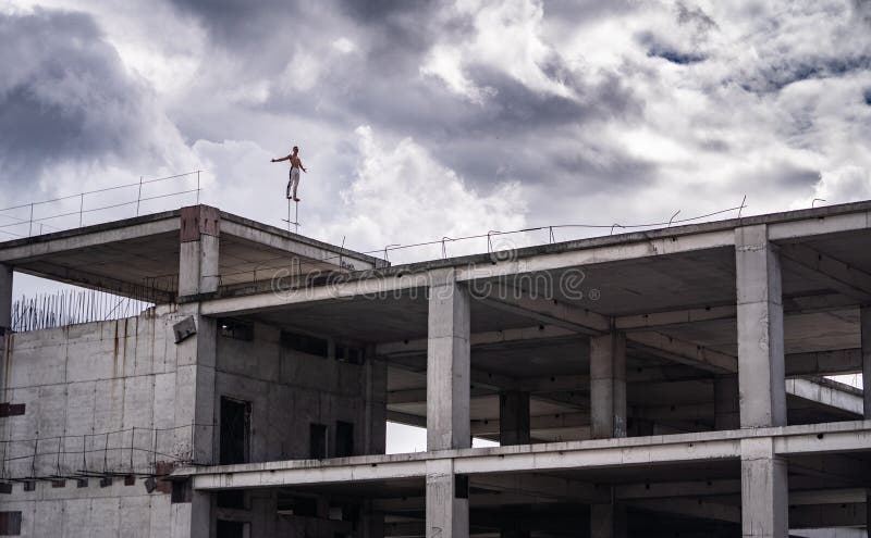 Man Standing on the Edge of Rooftop Unfinished Building with Dramatic ...