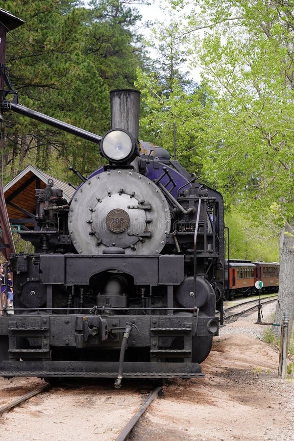 A Man Standing in Front of an Old Train Engine on Tracks Stock Image ...