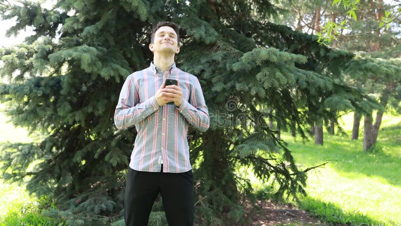 Man Standing in Front of Tree Using Cell Phone Stock Video - Video of ...