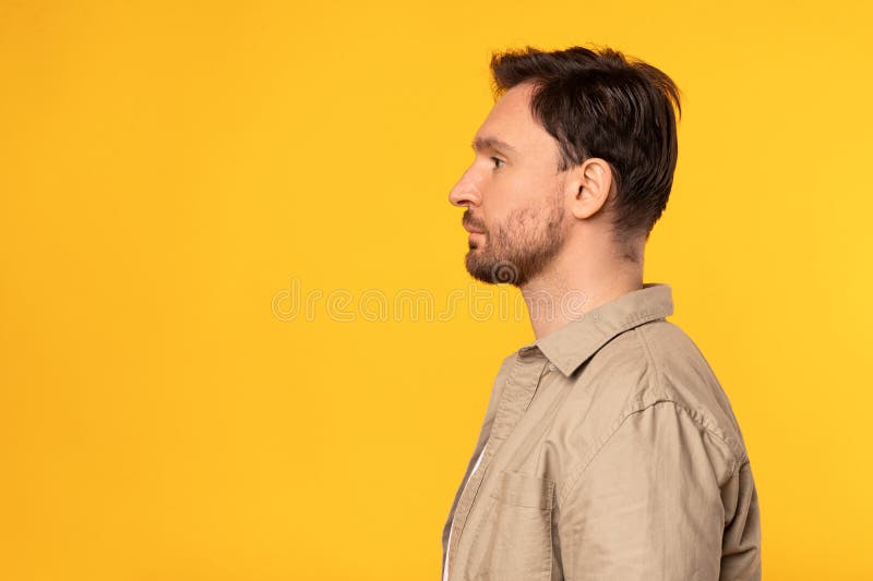 Man Standing in Front of Yellow Background, Profile View Stock Image ...
