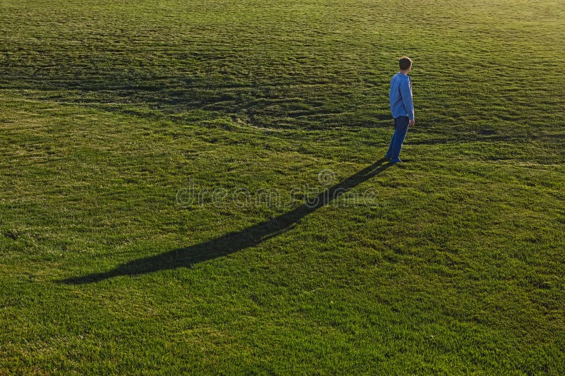 Man Standing on the Green Grass Lawn Stock Photo - Image of shadow ...