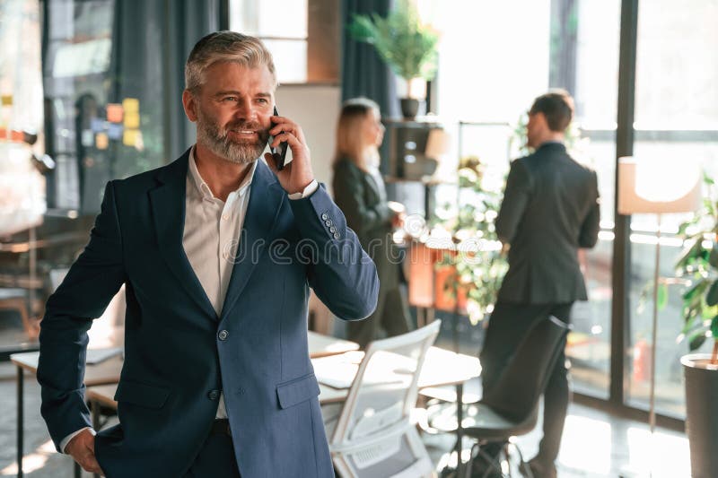 Man is Standing and Having Phone Call. Group of Business People are ...