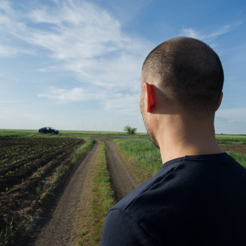 Man is Standing with His Back in the Field and Staring into the Stock ...