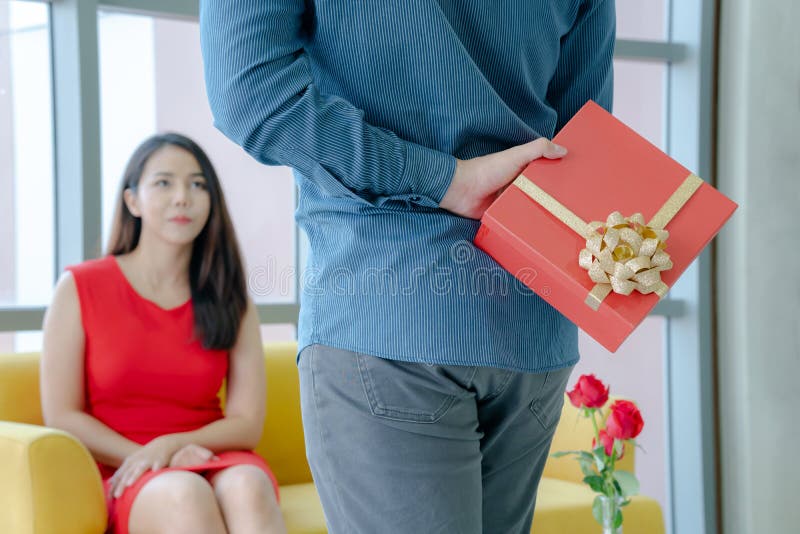 A Man Standing and Holding Gift Box Behind His Back. Making Surprise ...