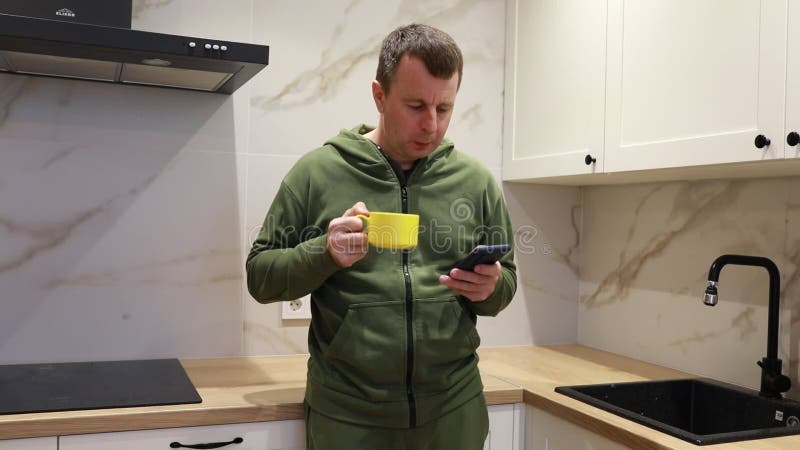 Man Standing in Kitchen Looking at Cell Phone Stock Video - Video of ...