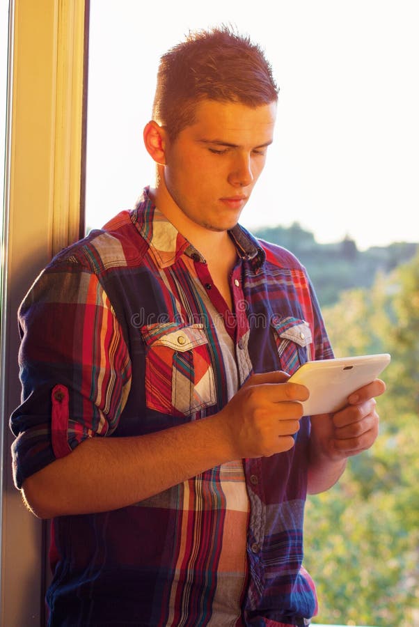 Man Standing Near Window at Sunshine Using Tablet Stock Photo - Image ...