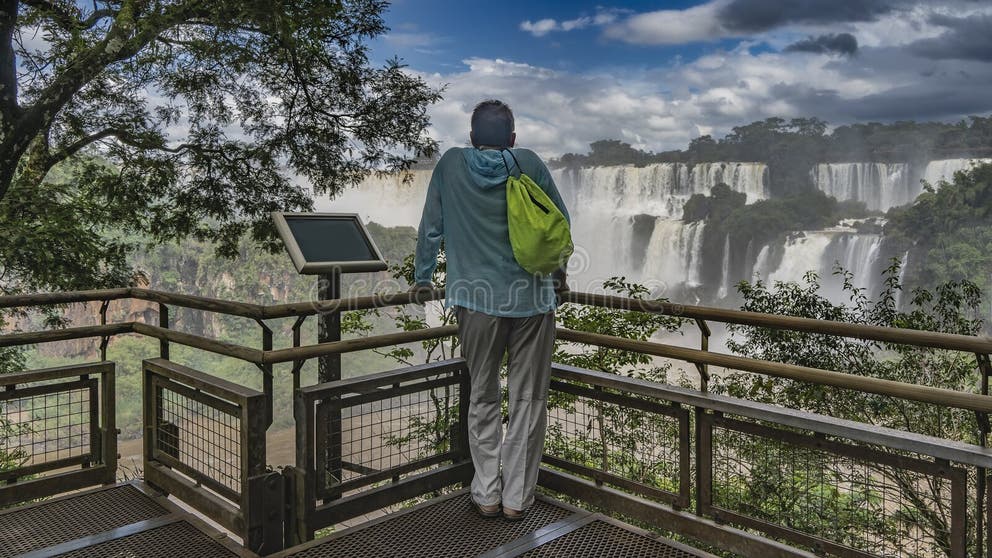 A Man is Standing on the Observation Deck, Leaning on the Railing ...