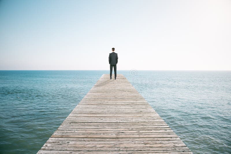 Man Standing on the Pier and Looking into the Distance of the Ocean ...