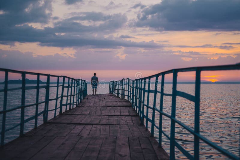 Man Standing on the Pier and Looking on Sunset Stock Photo - Image of ...