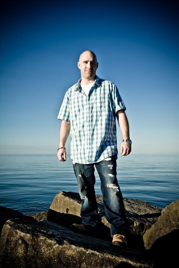 Man Standing on rocks stock photo. Image of leaning, male - 20129978