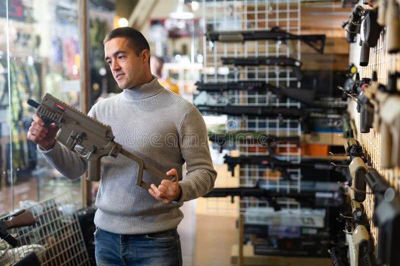 Man Choosing Machine Gun in Arms Shop Stock Photo - Image of customer ...
